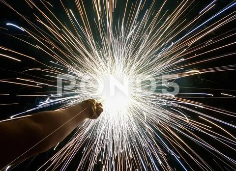 Photograph: Hand charki, a hand firework emitting circular sparks in ...