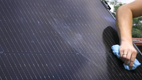 Hand cleaning a solar panel with a cloth | Stock Video | Pond5