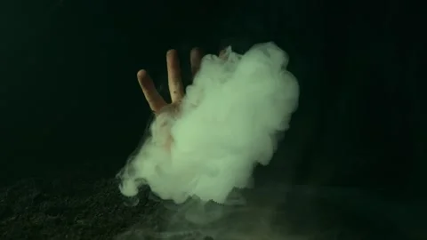 A hand in fumes of smoke emerges from th... | Stock Video | Pond5