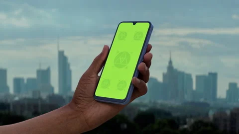 Hand holding a phone with a city skyline... | Stock Video | Pond5