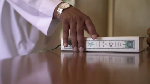Hand of Muslim Mullah picks up holy Qura... | Stock Video | Pond5