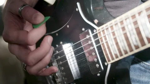 Hand with pick pulling black guitar's st... | Stock Video | Pond5