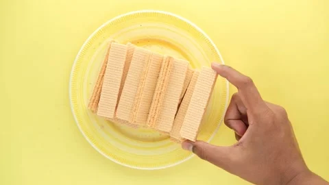 hand pick wafer roll chocolate from a pl... | Stock Video | Pond5