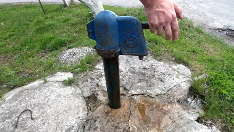 The hand presses the lever to draw water... | Stock Video | Pond5