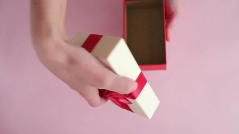 Hand put gift box on pink background and... | Stock Video | Pond5