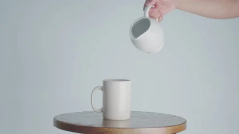 A Hand Reaching Out and Pouring Cream In... | Stock Video | Pond5