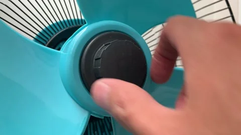 Hand rotate blue blade of electric fan. ... | Stock Video | Pond5