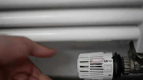 Hand turning dial on home radiator lower... | Stock Video | Pond5