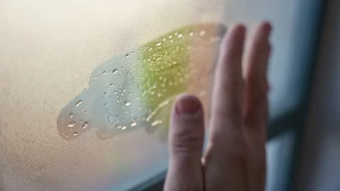 Hand wiping condensation on glass window... | Stock Video | Pond5
