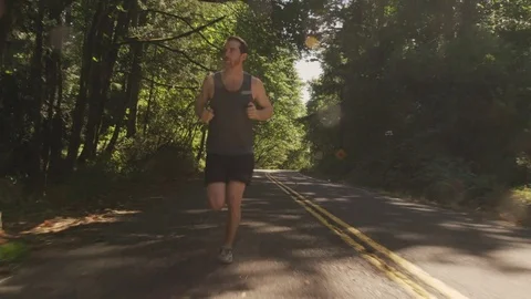 Handheld shot of young man running on ro... | Stock Video | Pond5