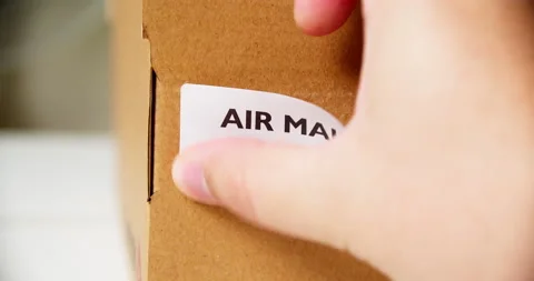 Hands applying AIR MAIL Sticker label on... | Stock Video | Pond5