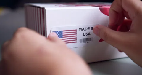 Hands applying MADE IN USA flag label on... | Stock Video | Pond5