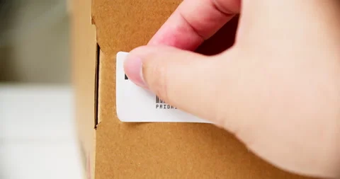Hands applying PRIORITY MAIL Sticker lab... | Stock Video | Pond5