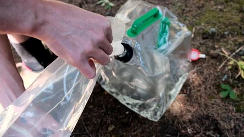 Hands of camper filtering spring water. ... | Stock Video | Pond5