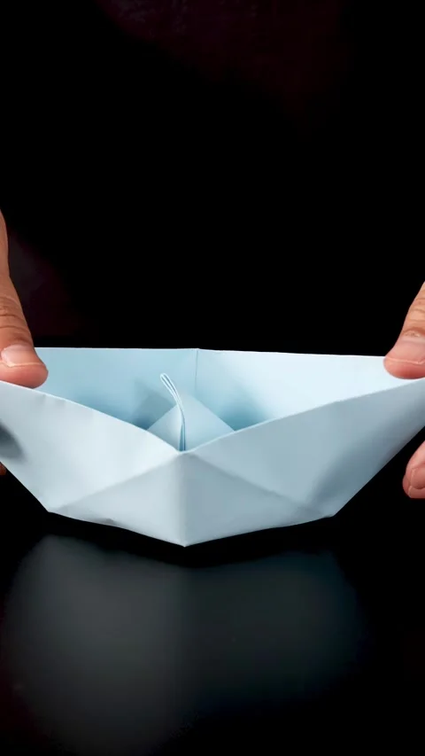 Hands Folding Blue Origami Paper Boat on... | Stock Video | Pond5