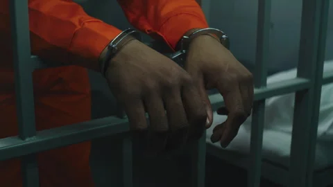 Hands in handcuffs leaning on prison cel... | Stock Video | Pond5