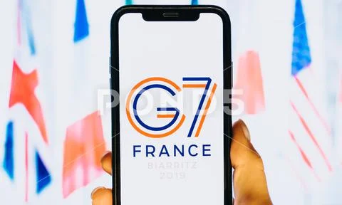 Hands holding iPhone X with G7 summit logo 2019 in France on the screen ...