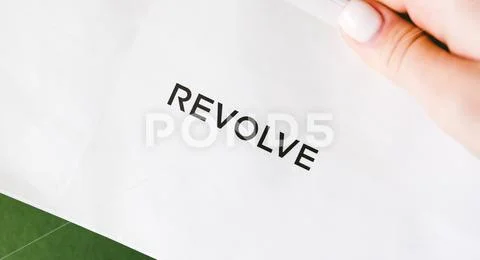 Hands holding Revolve logo on green background Stock Photo #131198580