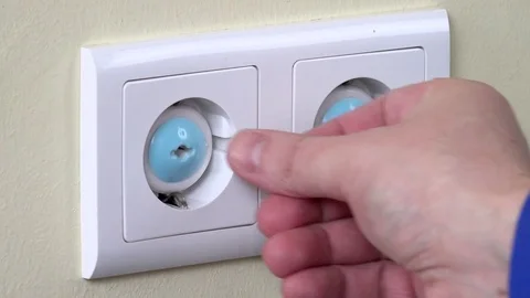 Hands install safety plugs in electricit... | Stock Video | Pond5
