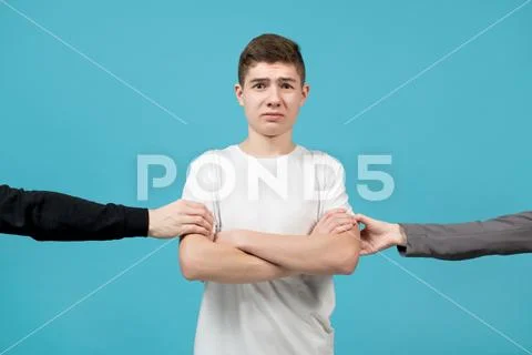 Hands of people behind the scenes pulling somewhere a young guy in a ...