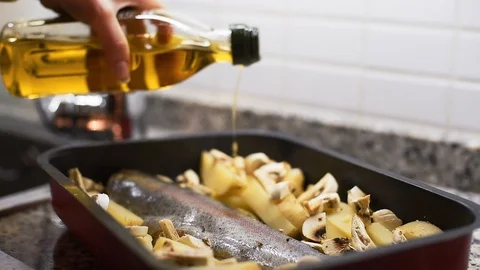 Hands pouring a fish dish with olive oil | Stock Video | Pond5