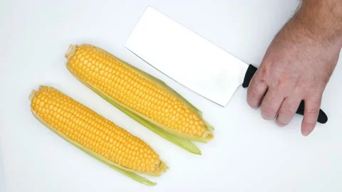 Hands put corn and knife on a white back... | Stock Video | Pond5