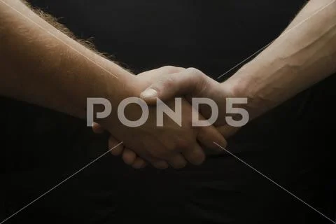 Hands shaking on the black background, Strong man hands. Del and ...