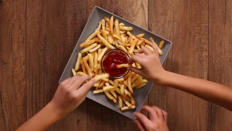 Hands taking french fries from a rotatin... | Stock Video | Pond5