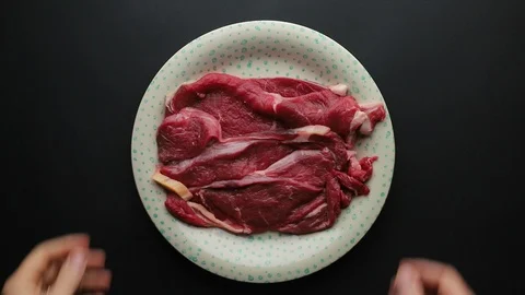 hands taking off a plate of raw meat fro... | Stock Video | Pond5