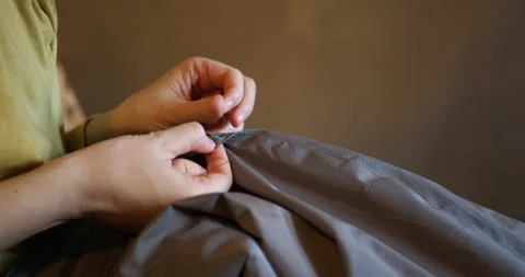 hands tying a knot of thread on gray pan... | Stock Video | Pond5