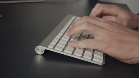 Hands typing at a wireless Apple Keyboar... | Stock Video | Pond5