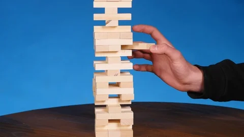 hands of Young man plays jenga on blue b... | Stock Video | Pond5