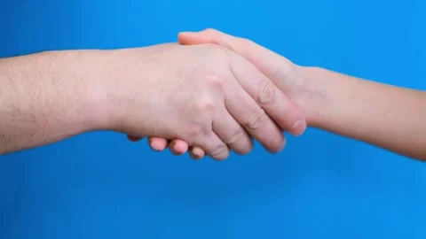 Handshake during a deal on a blue chroma... | Stock Video | Pond5
