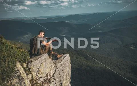 Photograph: Handsome hunter man holding gun and walking in forest. Male ...