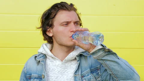 A handsome man is drinking water from a ... | Stock Video | Pond5