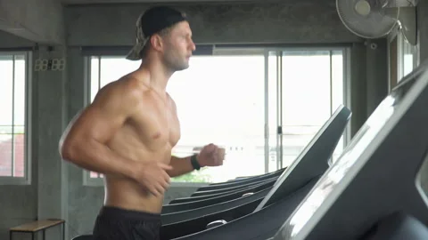 Handsome muscular man running on treadmi... | Stock Video | Pond5