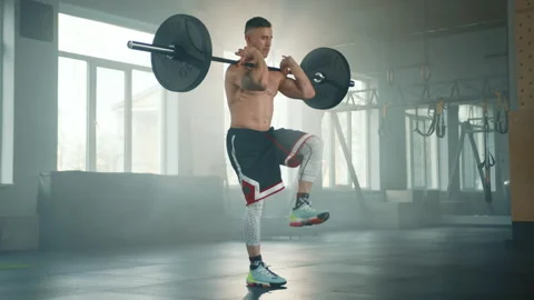 Handsome sportsman doing squats on one l... | Stock Video | Pond5