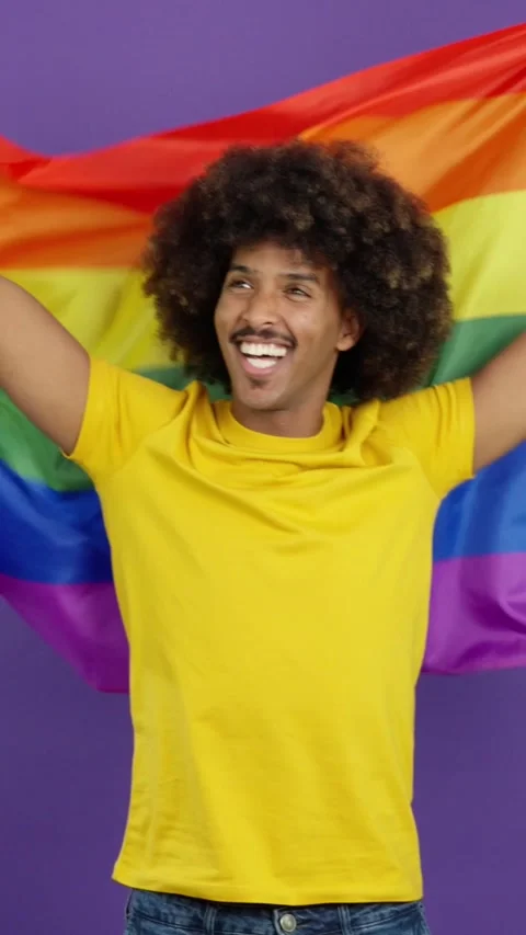 Happy african man raising a lgbt rainbow... | Stock Video | Pond5