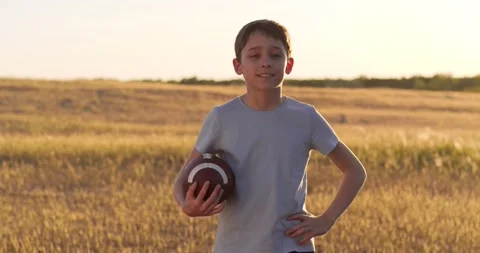 Happy boy rugby ball in hands at sunset.... | Stock Video | Pond5
