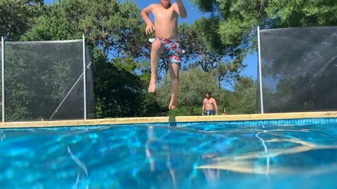 Happy boy running and jumping into swimm... | Stock Video | Pond5