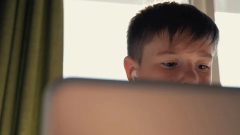 Happy boy sitting at his desk with lapto... | Stock Video | Pond5