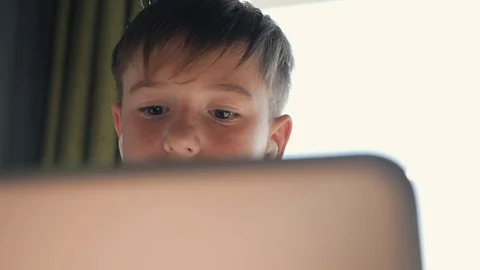 Happy boy sitting at his desk with lapto... | Stock Video | Pond5