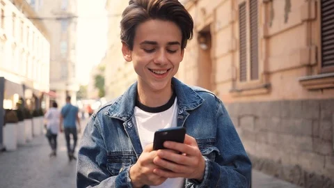 Happy boy using mobile phone smiling han... | Stock Video | Pond5