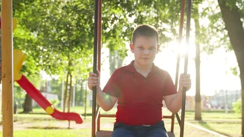Happy child boy swinging high on swing o... | Stock Video | Pond5