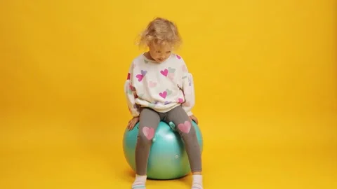 Happy child jumping on bouncing ball. To... | Stock Video | Pond5