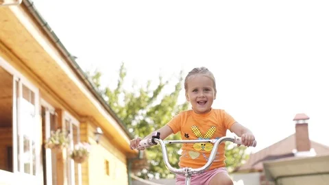 Happy child riding a bike. Girl on a bic... | Stock Video | Pond5