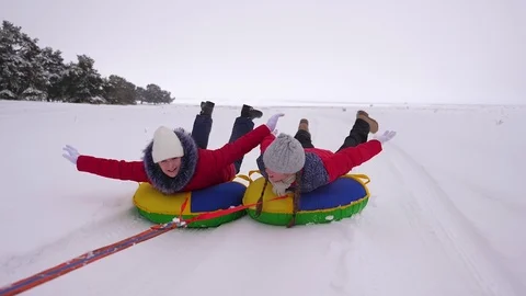 Happy children teenagers roll on snowy p... | Stock Video | Pond5