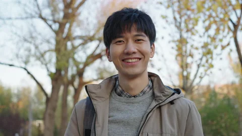 Happy Chinese college boy reading a book | Stock Video | Pond5