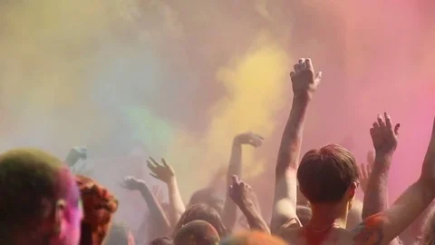 Happy crowd throwing colorful powder and... | Stock Video | Pond5