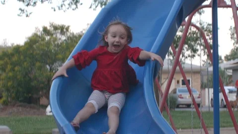 Happy Cute Girl Sliding Down a Playgroun... | Stock Video | Pond5